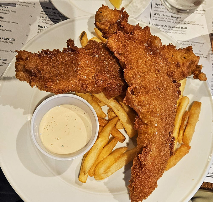 Golden-battered fish that shatters at first bite, paired with fries that achieve that perfect crisp-outside, fluffy-inside nirvana—the fish and chips here are no mere afterthought.