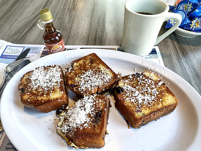 French toast that's had a proper education—golden-crisp exterior, custardy interior, and a snowfall of powdered sugar that makes resistance futile.