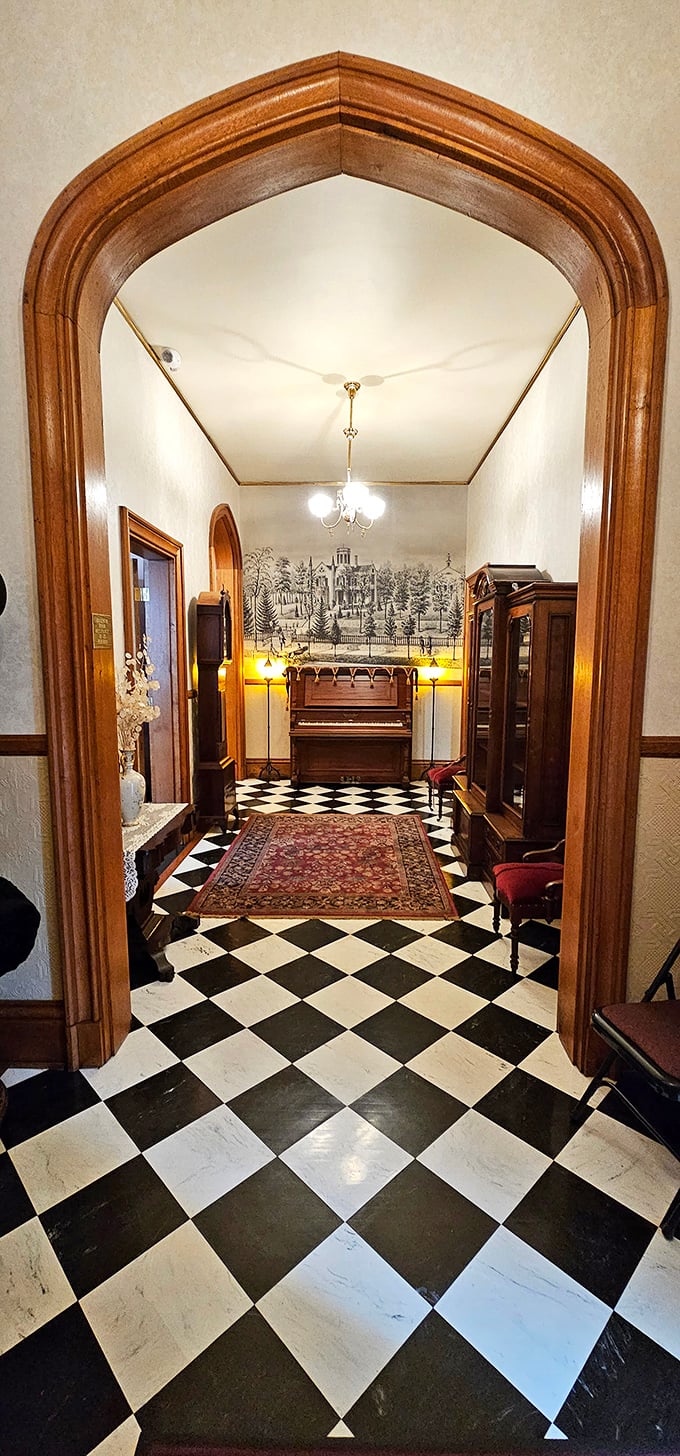 Checkerboard floors and Gothic arches—this hallway wasn't designed for rushing. It was made for dramatic entrances and meaningful exits.