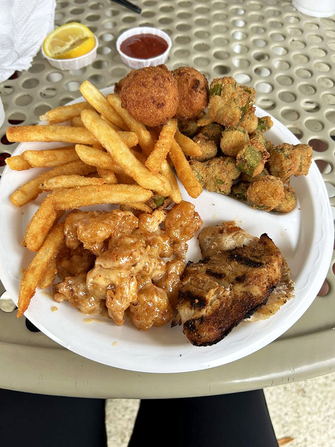 This isn't just a meal; it's a Gulf Coast symphony on a plate—crispy hushpuppies, golden fries, and that Bang Bang Shrimp stealing the spotlight. 