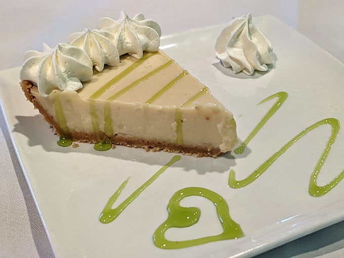 Key lime pie perfection: pale yellow custard meets graham cracker crust in holy matrimony. Those artful lime drizzles aren't just for show—they're flavor exclamation points.