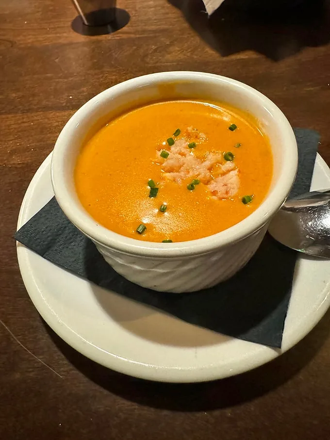 This isn't just soup—it's a sunset-colored bowl of happiness, garnished with fresh chives and lobster meat that's practically waving hello.