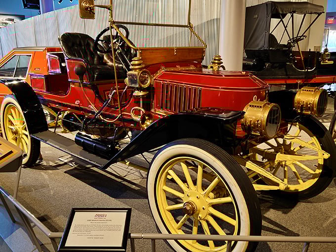 This gleaming vintage automobile with its bright red finish and brass accents isn't just a car—it's a time capsule with an engine, capturing an era when driving was an adventure.