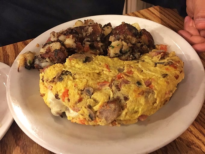 This isn't just any omelet—it's a fluffy golden canvas where vegetables and protein unite in perfect harmony. The crispy potatoes deserve their own fan club.