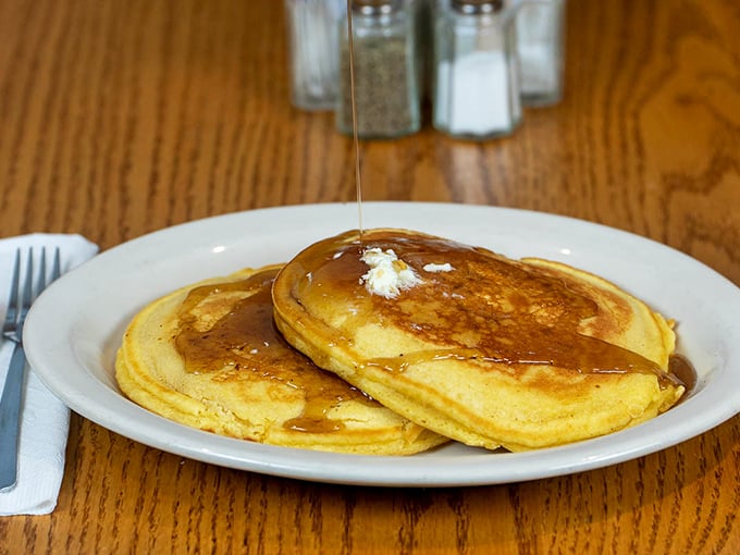 Golden-edged pancakes waiting for their maple syrup baptism—these fluffy discs of joy could convert even the most dedicated egg enthusiast.
