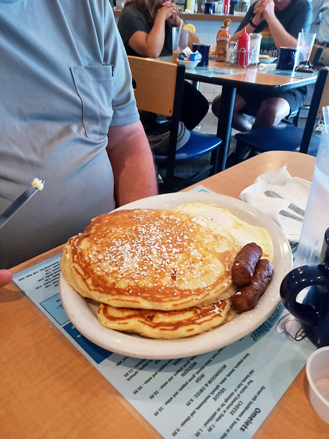 Golden pancakes dusted with powdered sugar alongside sausage links—the breakfast equivalent of a warm hug from your favorite aunt.