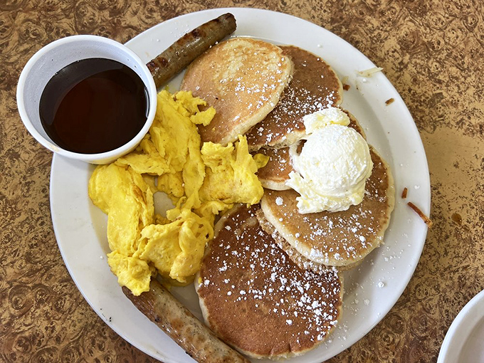 Pancake perfection meets scrambled sunshine on a plate. That powdered sugar dusting isn't just garnish—it's breakfast pixie dust.