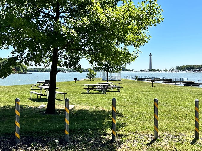 Picnic tables under dappled shade – where PB&Js taste like gourmet fare and conversations pause mid-sentence when sailboats glide by.