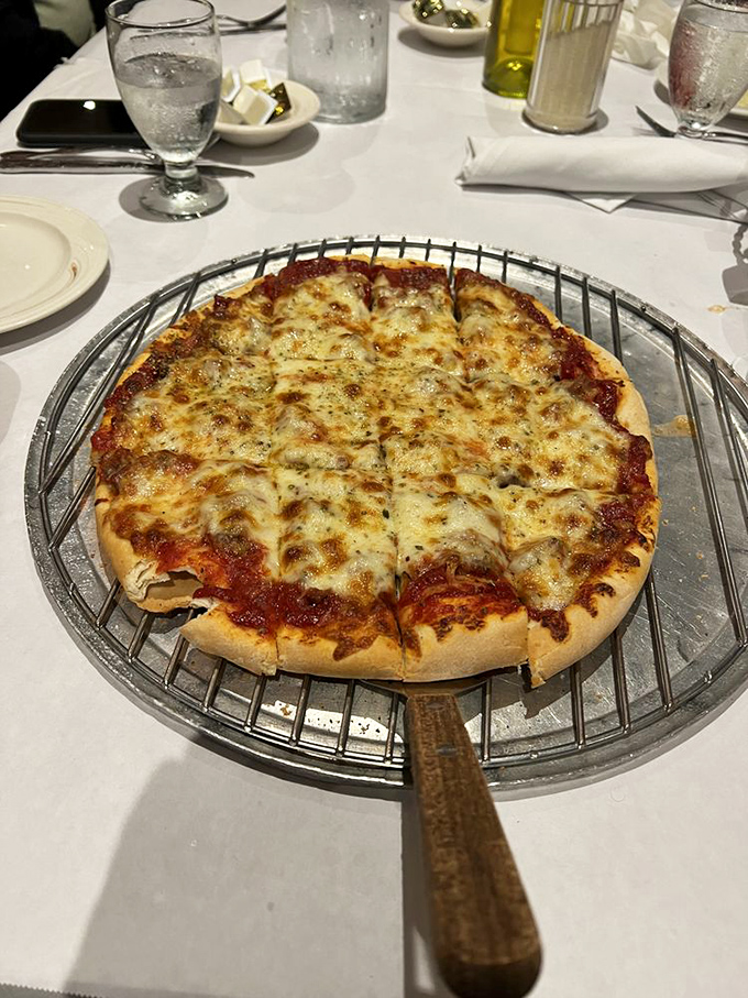 Behold the thin crust pizza in all its glory—perfectly browned cheese, that ideal sauce-to-crust ratio, and a metal serving stand that means business.