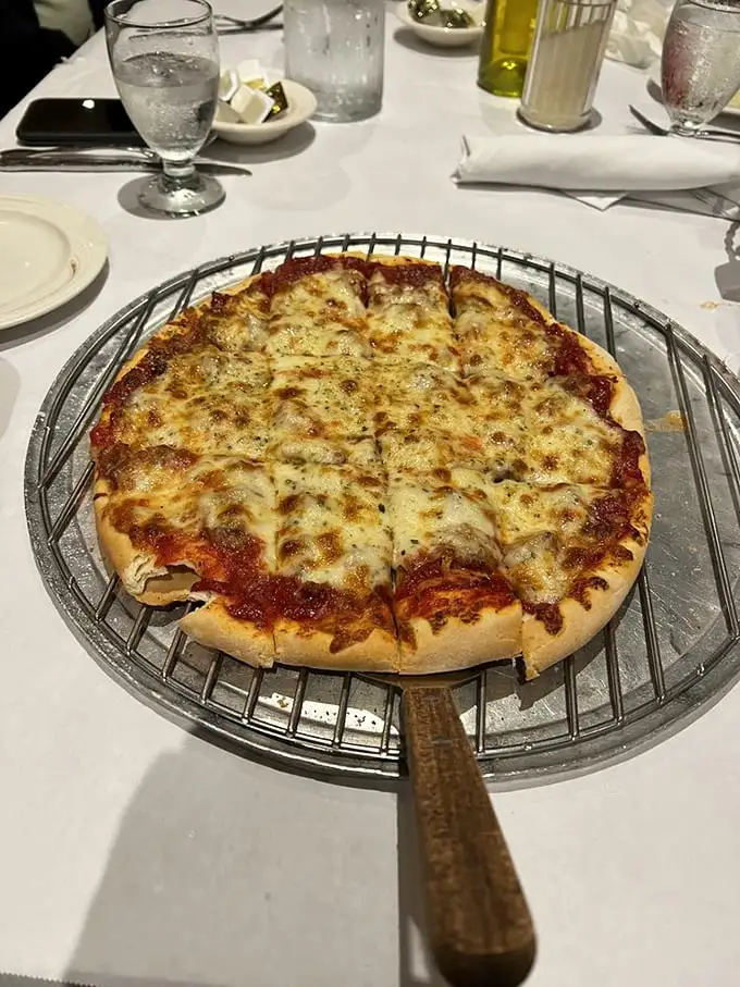 Behold the thin crust pizza in all its glory—perfectly browned cheese, that ideal sauce-to-crust ratio, and a metal serving stand that means business.