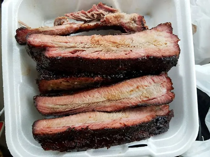 These ribs don't just fall off the bone—they practically leap into your mouth, sporting that perfect pink smoke ring that BBQ aficionados dream about.
