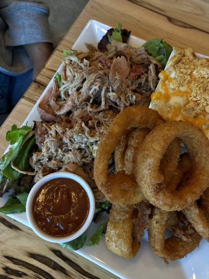 Pulled pork that looks like it's been practicing the art of falling apart for years, alongside golden onion rings that crunch loud enough to turn heads.