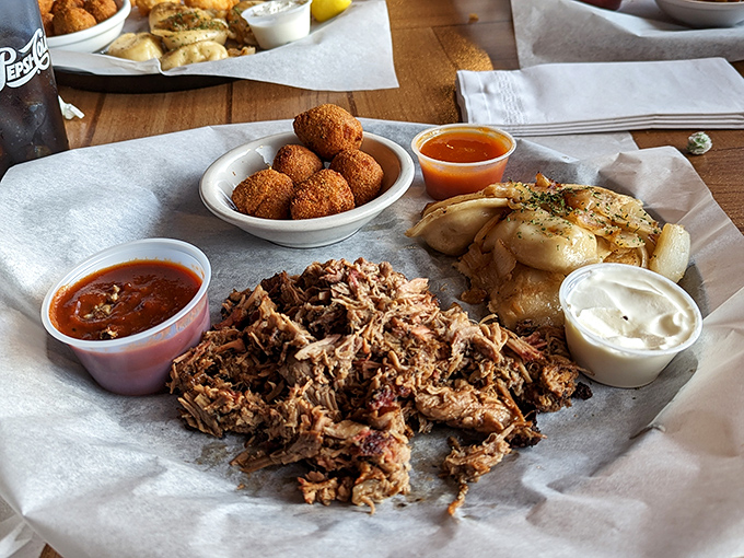 This pulled pork plate isn't messing around. Tender, smoky meat alongside golden hush puppies and pierogies—a Midwest meets South Carolina love story on a plate.