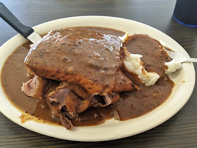 This isn't just roast beef—it's a gravy-laden monument to comfort food, where mashed potatoes stand ready to soak up every last drop.