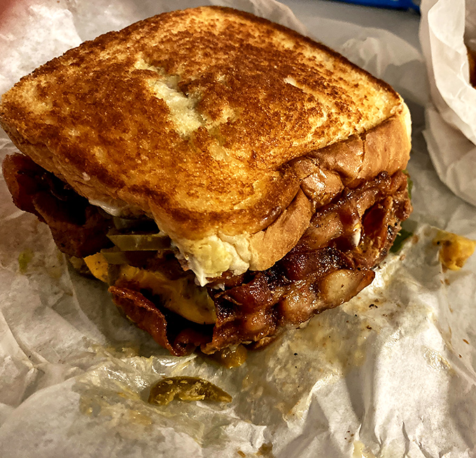 This isn't just a sandwich; it's edible architecture. Golden toasted bread barely containing a masterpiece of melted cheese and savory fillings.
