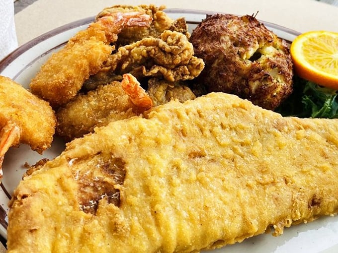 A seafood platter that makes decisions easy—golden fried fish, plump shrimp, and that crab cake stealing the spotlight like a Broadway veteran.