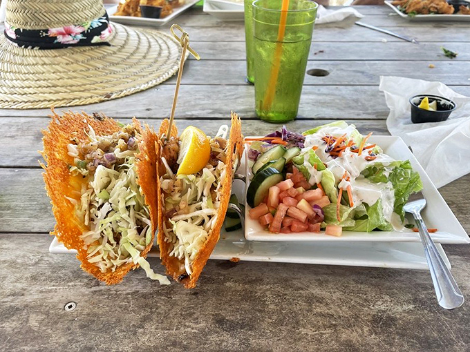 These aren't your average tacos—crispy cheese fans cradle fresh grouper while a side salad pretends you're making healthy choices.