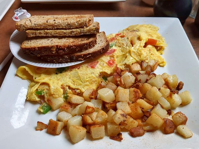 Breakfast geometry at its finest—perfectly golden omelet, crispy home fries, and hearty toast forming the triangle of morning happiness.