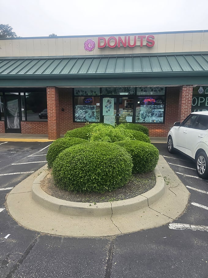 Classic brick and green trim architecture that whispers "we've been perfecting donuts for years."