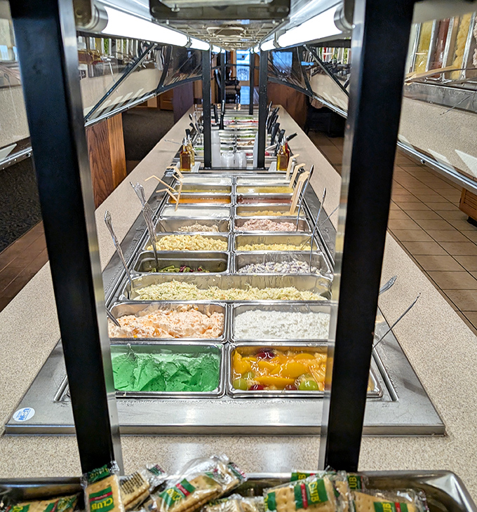The buffet stretches toward the horizon like a promised land of home cooking. Each metal pan holds treasures more valuable than gold to a hungry traveler.