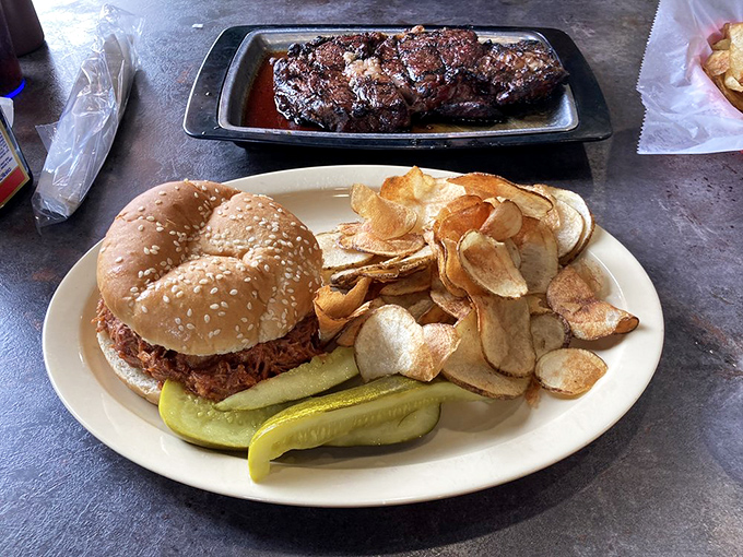The pulled pork sandwich comes with homemade chips that shatter with each bite – proof that even the supporting actors in this meat-centric drama deserve standing ovations.