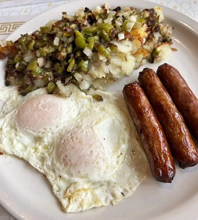 Home fries loaded with peppers and onions, perfectly cooked eggs, and sausage links that snap with joy—breakfast doesn't get more sincere than this.