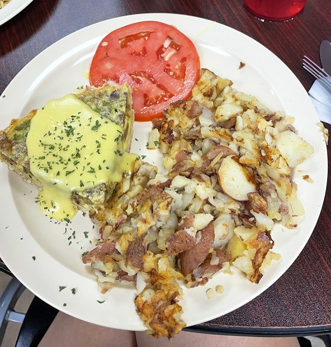 Breakfast geometry at its finest—golden triangles of egg perfection nestled beside home fries that could make a potato farmer weep with pride.