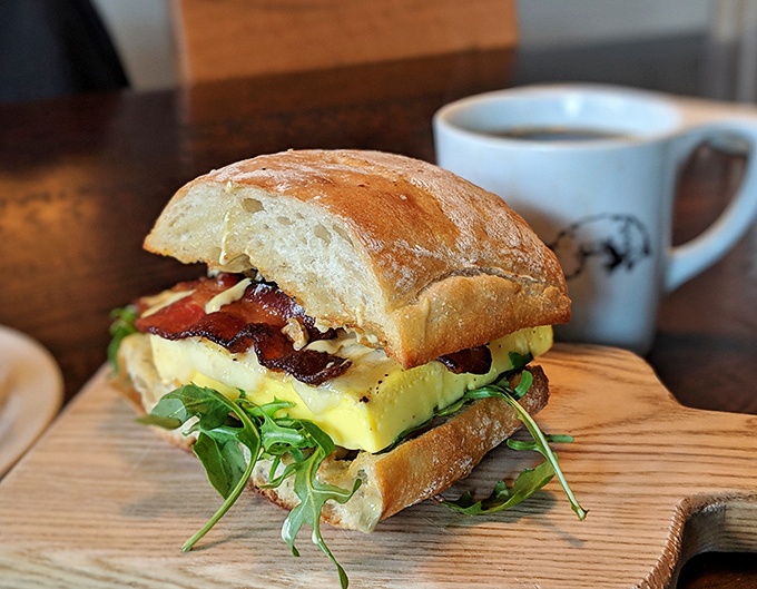 This isn't just a breakfast sandwich—it's architectural genius. Souffléd eggs, crisp bacon, and fresh greens create the Taj Mahal of morning meals.