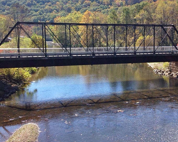 This isn't just any bridge—it's a portal connecting today's peaceful countryside with yesterday's industrial revolution, spanning more than just water.