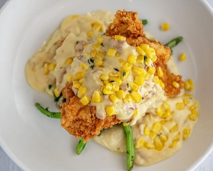 Southern comfort meets culinary artistry—this buttermilk fried chicken with corn cream sauce might make you temporarily forget you're in a seafood restaurant.