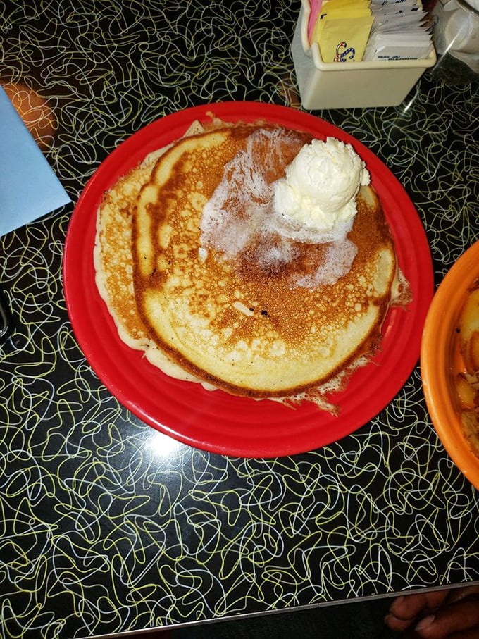 This pancake doesn't just sit on the plate—it commands it, with a dollop of butter melting like a morning sun.