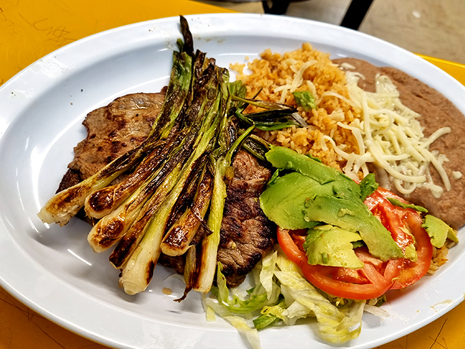 This isn't just carne asada – it's a plate of grilled steak nirvana with all the fixings, including those perfectly charred green onions that deserve their own fan club.