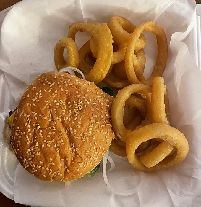 This isn't just a burger—it's therapy on a sesame seed bun, with golden onion rings that crunch loud enough to turn heads.