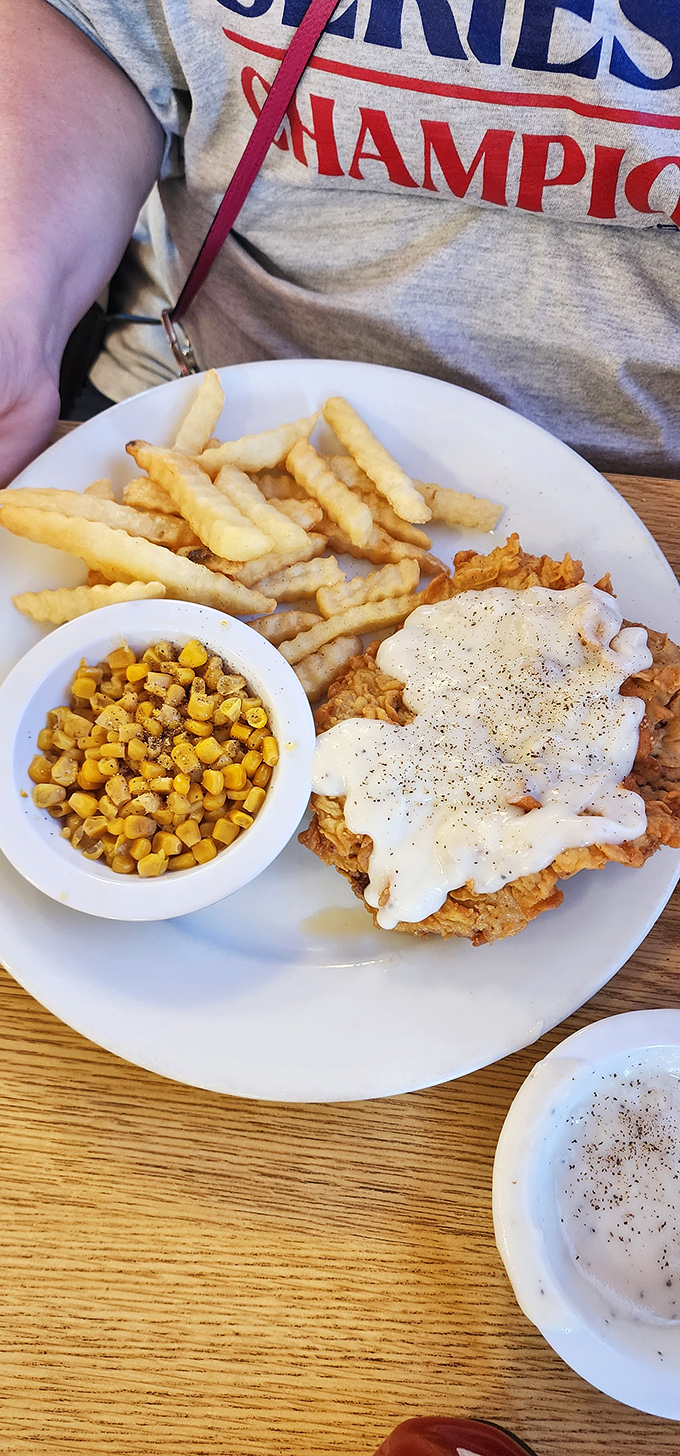 This isn't just comfort food—it's therapy on a plate. Crispy fries, sweet corn, and chicken fried something smothered in peppery gravy.