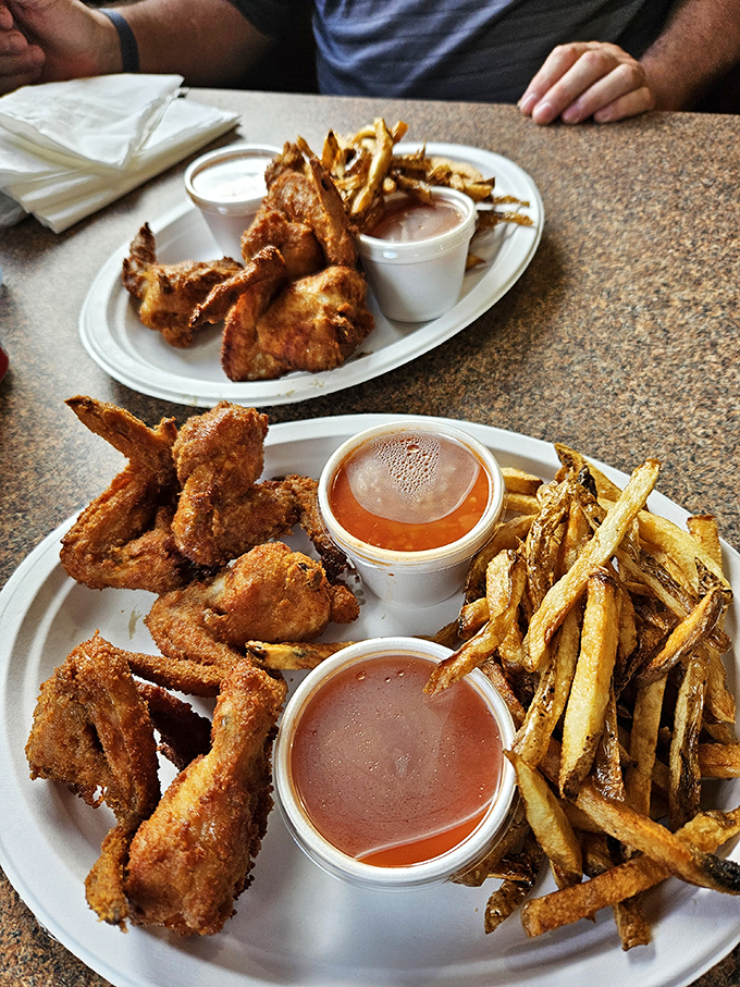 These aren't just wings – they're flavor vessels with a purpose. Crisp exterior, juicy interior, and that signature hot sauce standing by for dunking duty.