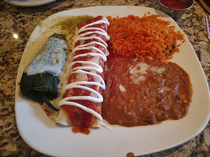 Behold the chimichanga in its natural habitat—crispy, sauce-draped, and flanked by rice and beans. That drizzle of sour cream is like the bow on a delicious present.