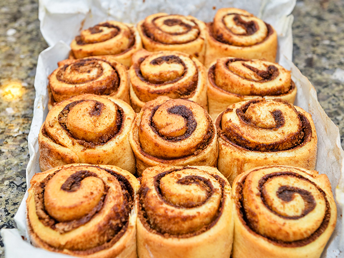 Cinnamon rolls so perfect they'd make a pastry chef weep. The spiral pattern isn't decorative—it's nature's way of hypnotizing you into ordering a dozen.