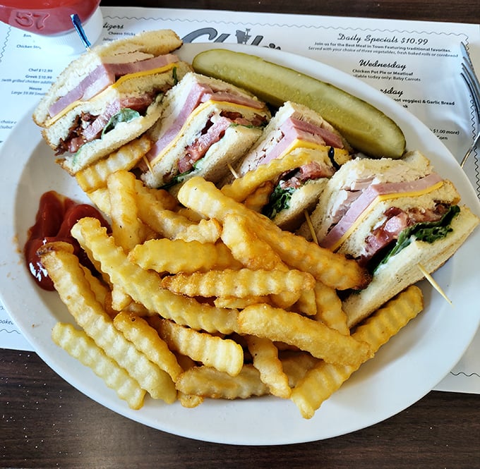 The club sandwich—architecture you can eat! Layers of deliciousness held together by toothpicks and tradition, with a golden fence of fries.