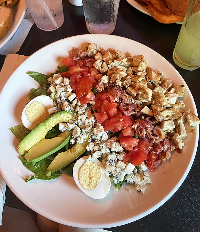Not just any Cobb salad—this is a masterpiece of careful arrangement. Avocado, egg, bacon, tomato, and blue cheese creating a symphony of flavors that somehow feels both indulgent and virtuous.