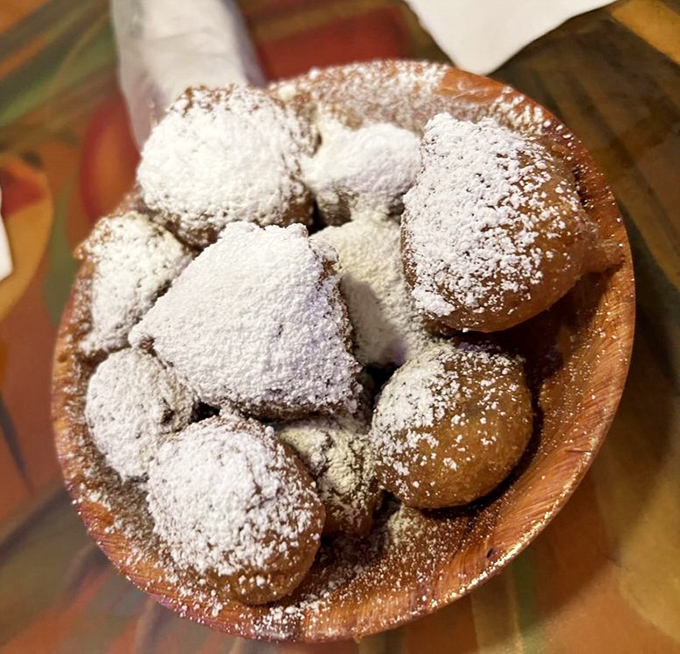 These powdered sugar-dusted fritters aren't just dessert—they're little clouds of fried happiness that make you forget you came for seafood in the first place.