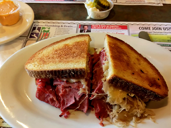 A proper deli sandwich isn't just lunch—it's architecture. This towering corned beef masterpiece requires both hands and absolutely no distractions.