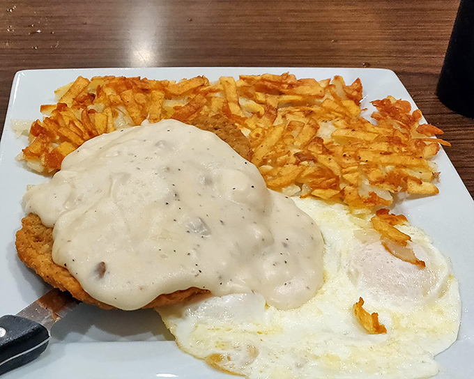 Country fried steak so tender it practically cuts itself, drowning in creamy white gravy perfection. 