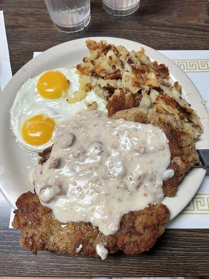 Country fried steak smothered in creamy gravy alongside sunny-side-up eggs. This plate doesn't just feed you—it hugs you from the inside out.
