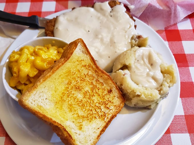 Southern comfort on a plate: golden mac and cheese, buttery toast, and mashed potatoes swimming in gravy. Carb counters, look away – this is worth every delicious calorie.