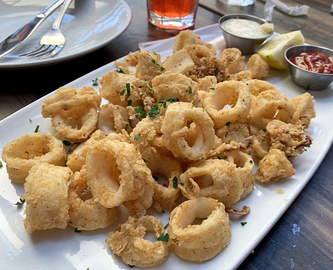 Crispy calamari that shatters like delicate glass with each bite – the perfect shareable starter that inevitably leads to fork jousting for the last piece.