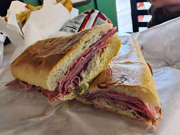 Behold the Cuban sandwich in its natural habitat—pressed to perfection with layers of meat and cheese playing together like a well-rehearsed symphony.