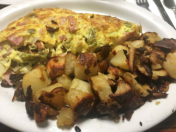 This Denver omelet with home fries isn't just breakfast—it's edible architecture, with each ingredient playing its crucial structural and flavor role to perfection.