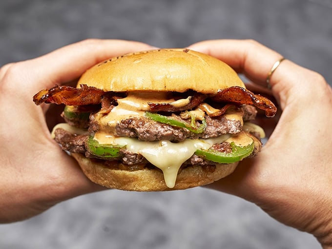 This isn't just a burger – it's architecture. Melty cheese cascades over double patties while jalapeños and bacon add that perfect flavor counterpoint. 