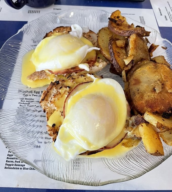 These eggs Benedict aren't just perfectly poached—they're having the time of their lives swimming in hollandaise while lounging on what appears to be Canadian bacon royalty.