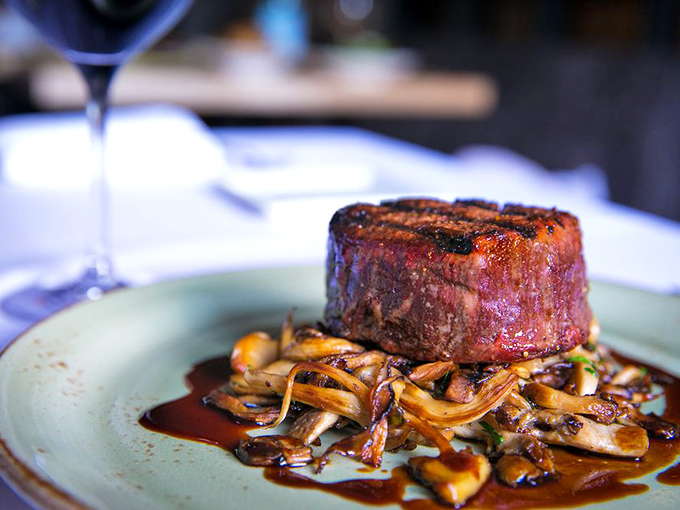 This isn't just a steak—it's a masterclass in simplicity. Perfectly seared filet mignon resting on a bed of wild mushrooms that whisper "autumn in Italy."